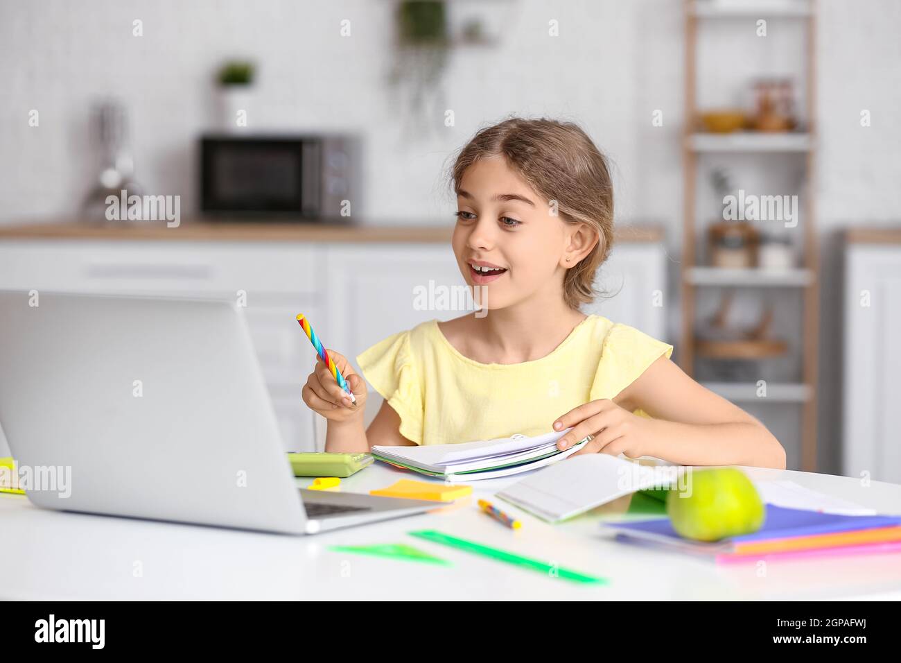 Little girl doing lessons online at home Stock Photo - Alamy