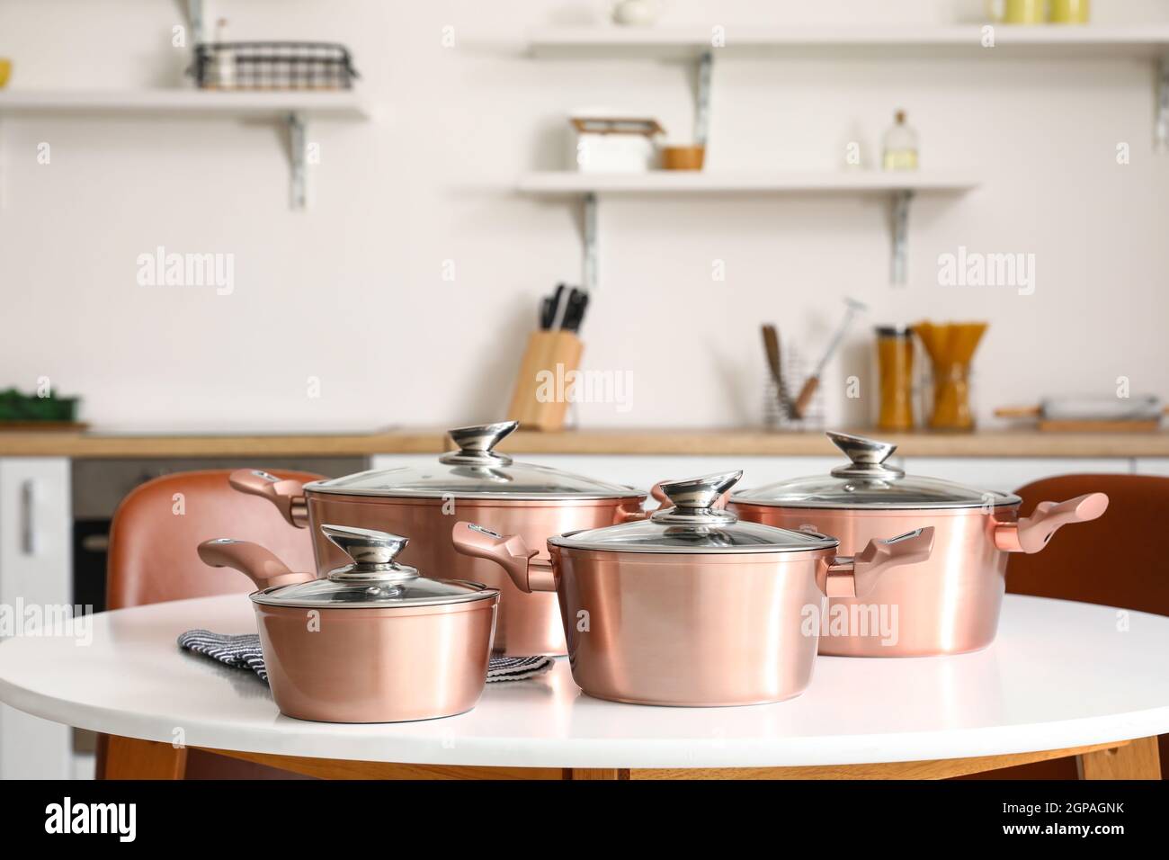 Set of copper cooking pots on table in kitchen Stock Photo - Alamy