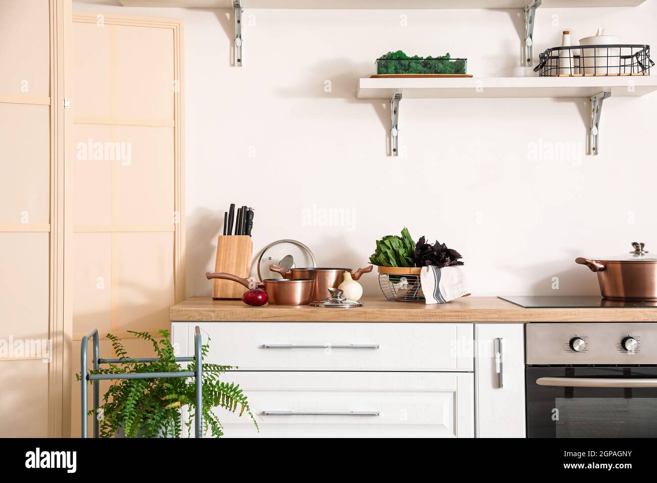 Cooking pots with vegetables and knives on kitchen counter Stock Photo ...