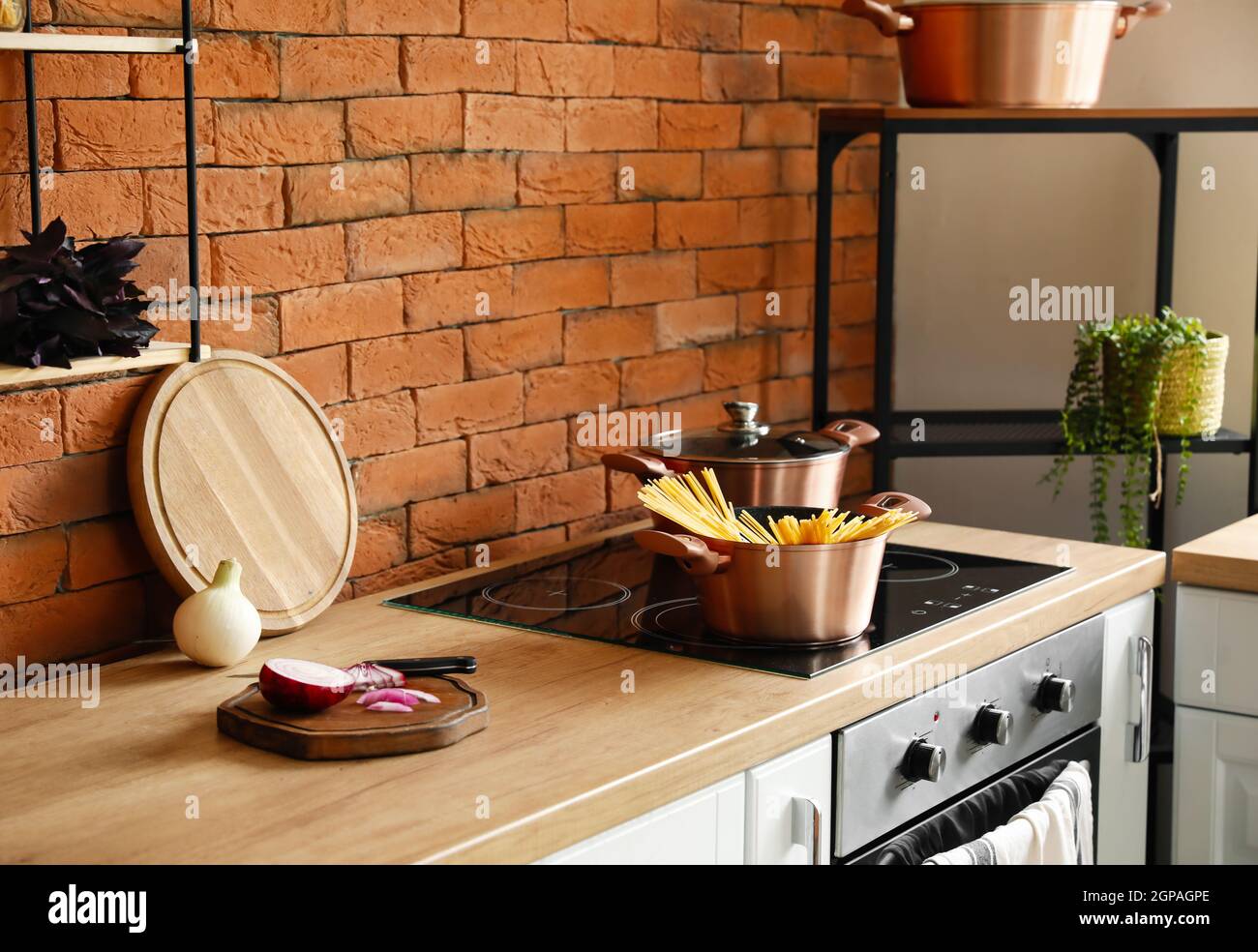 Copper cooking pots with raw spaghetti on stove in modern kitchen Stock ...