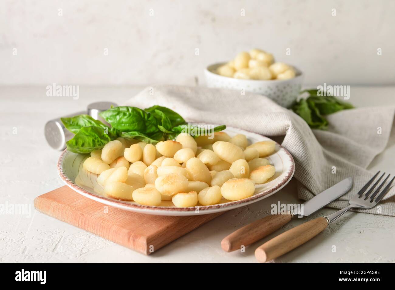 Plate with tasty gnocchi on light background Stock Photo - Alamy