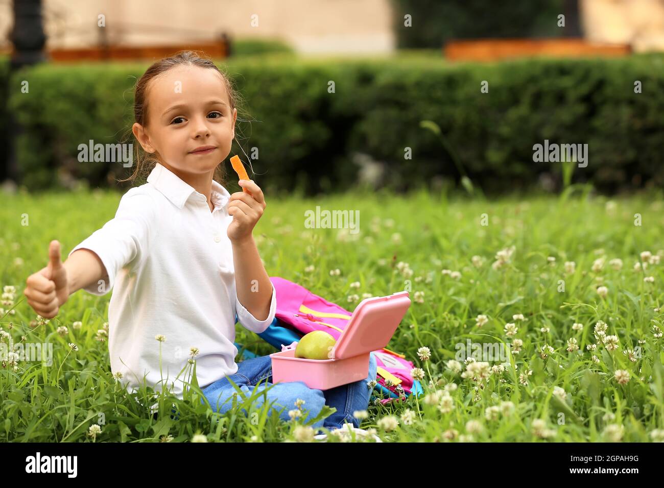 Cute little girl having school lunch outdoors Stock Photo - Alamy