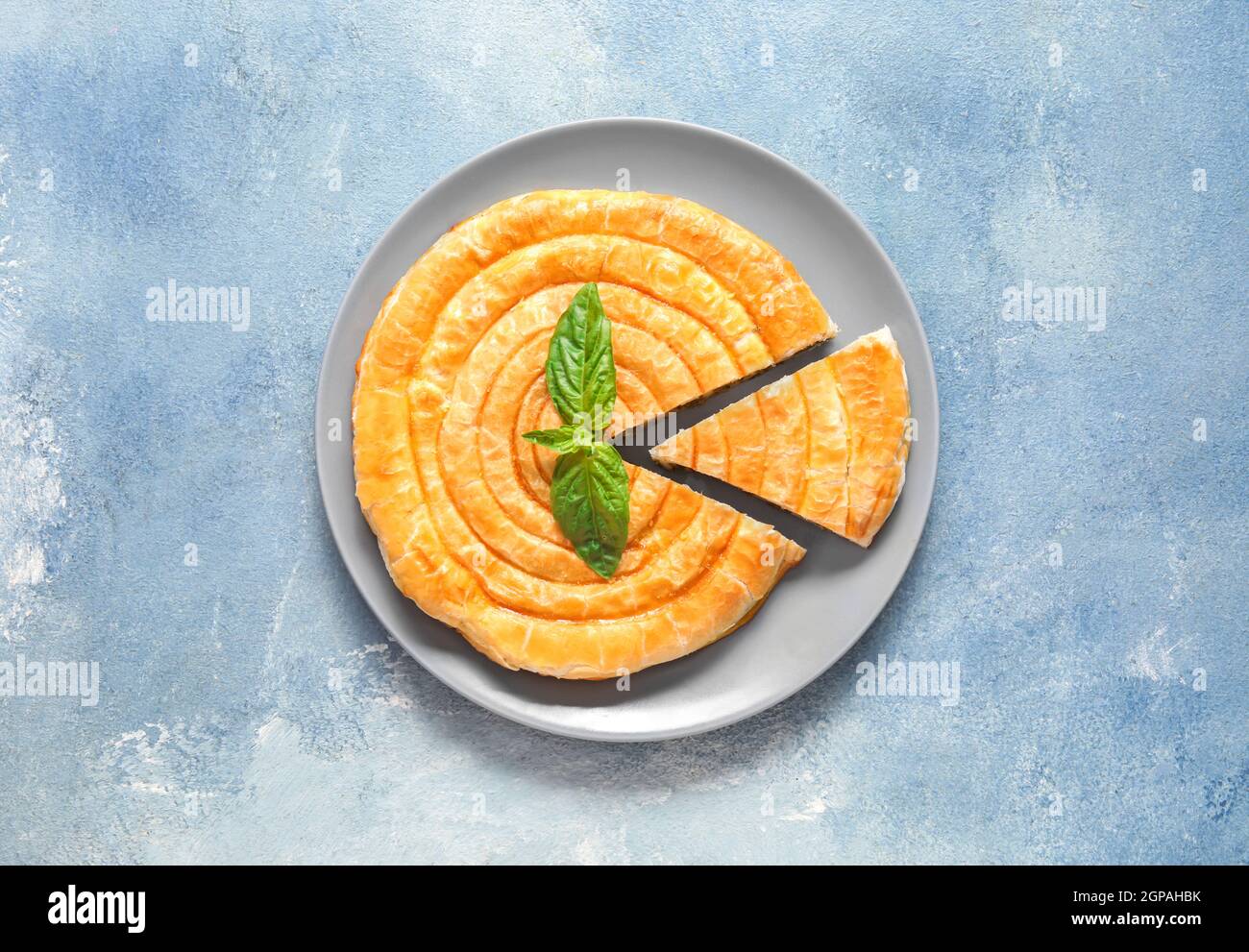 Plate with tasty spinach pie on color background Stock Photo - Alamy
