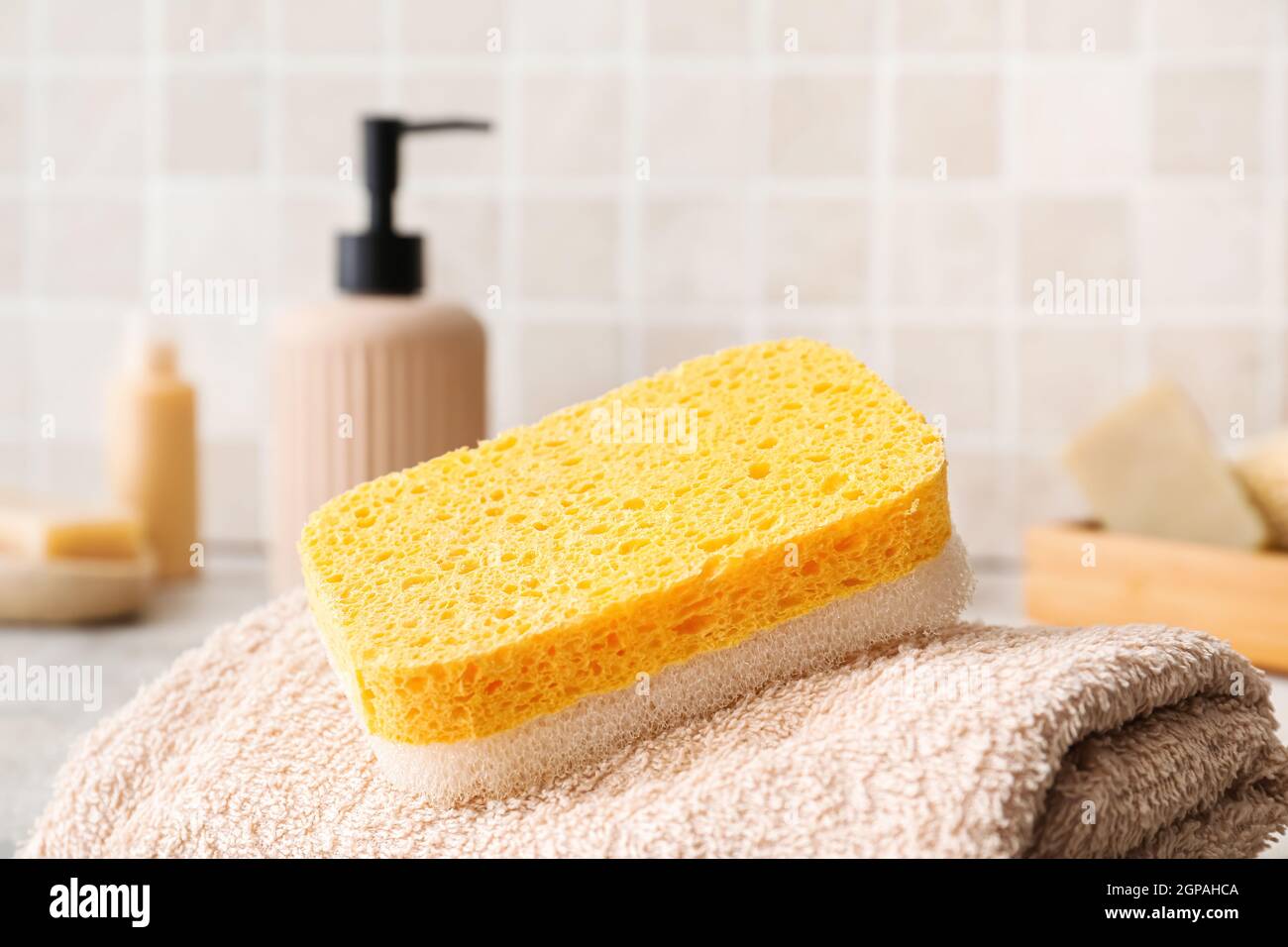 Bath sponge on towel in bathroom Stock Photo - Alamy
