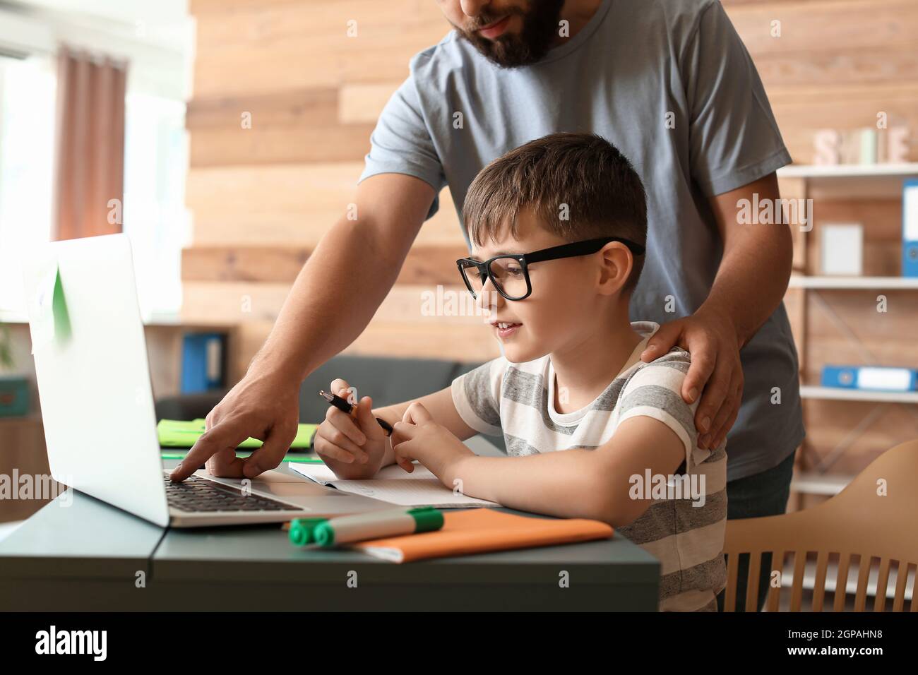 Little boy with his father doing lessons online at home Stock Photo - Alamy