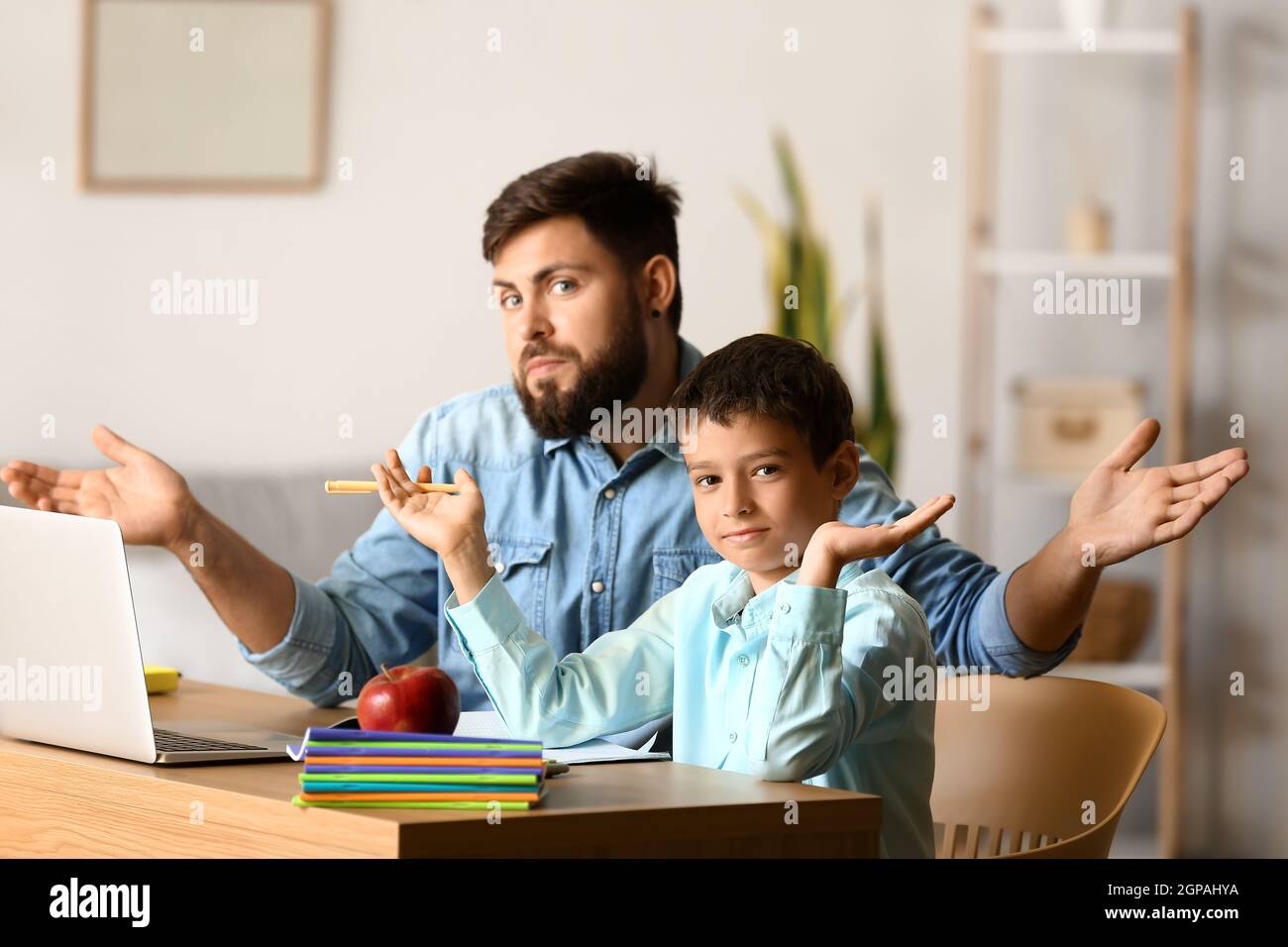 Confused little boy and his father doing lessons at home Stock Photo ...