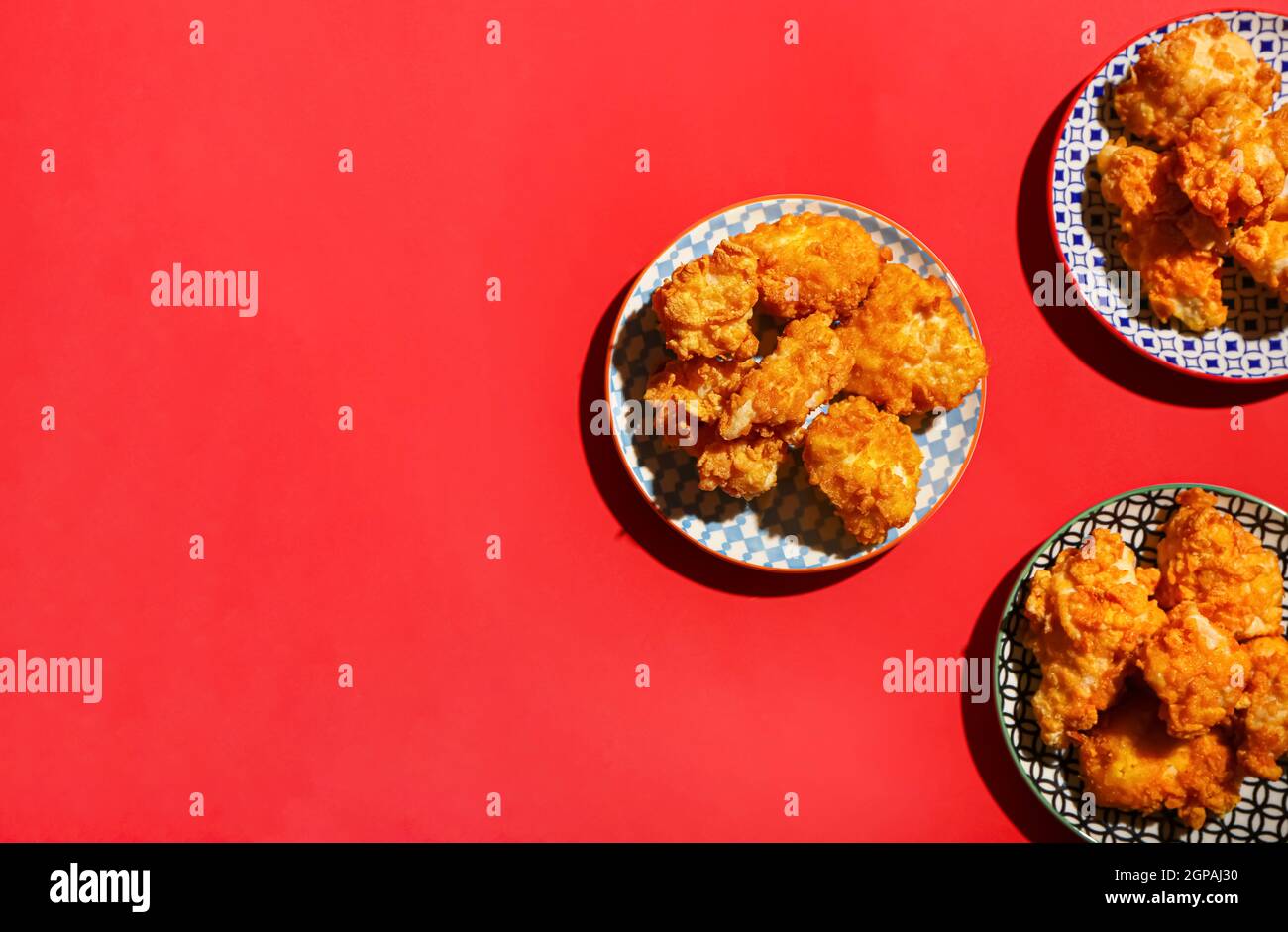 Plates with popcorn chicken on color background Stock Photo - Alamy