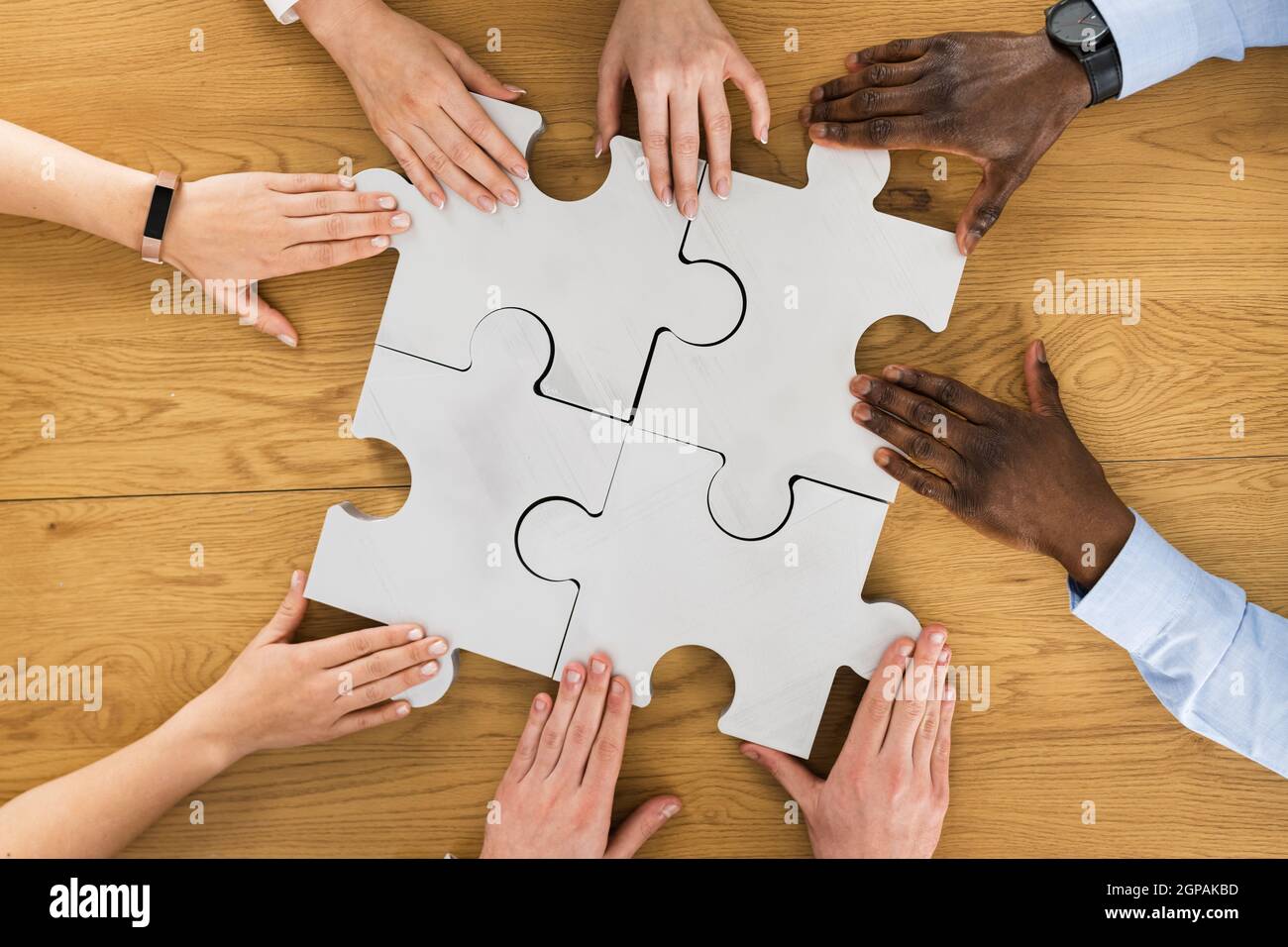 Teamwork Meeting Hands Solving Jigsaw Puzzle. Overhead View Stock Photo ...