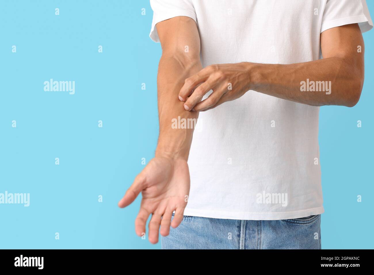 Young man scratching himself on color background Stock Photo - Alamy