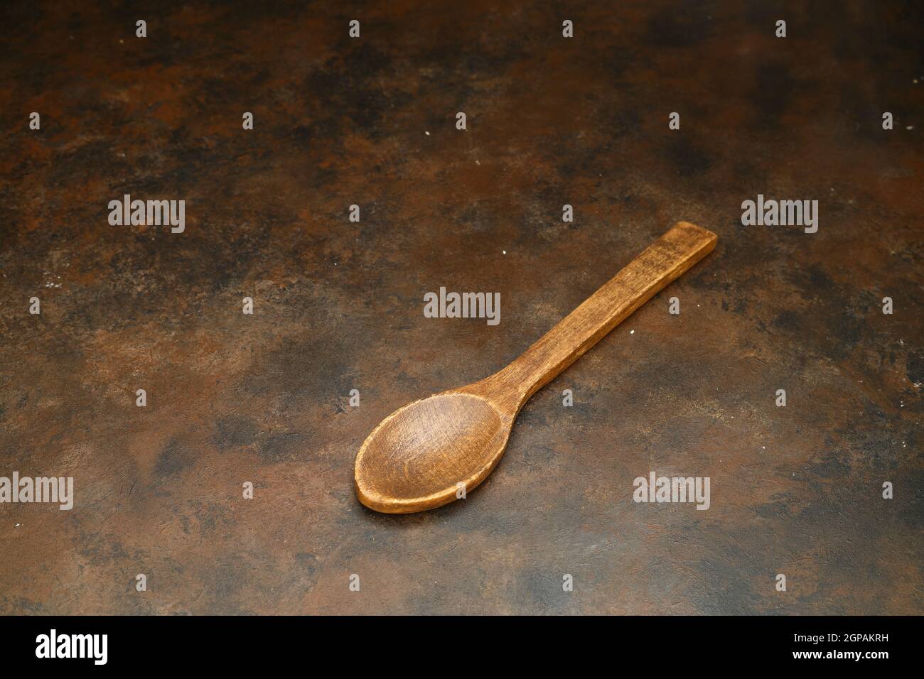 Wooden spoon on a rusty background. Wooden dishes. Isolate on a rusty ...