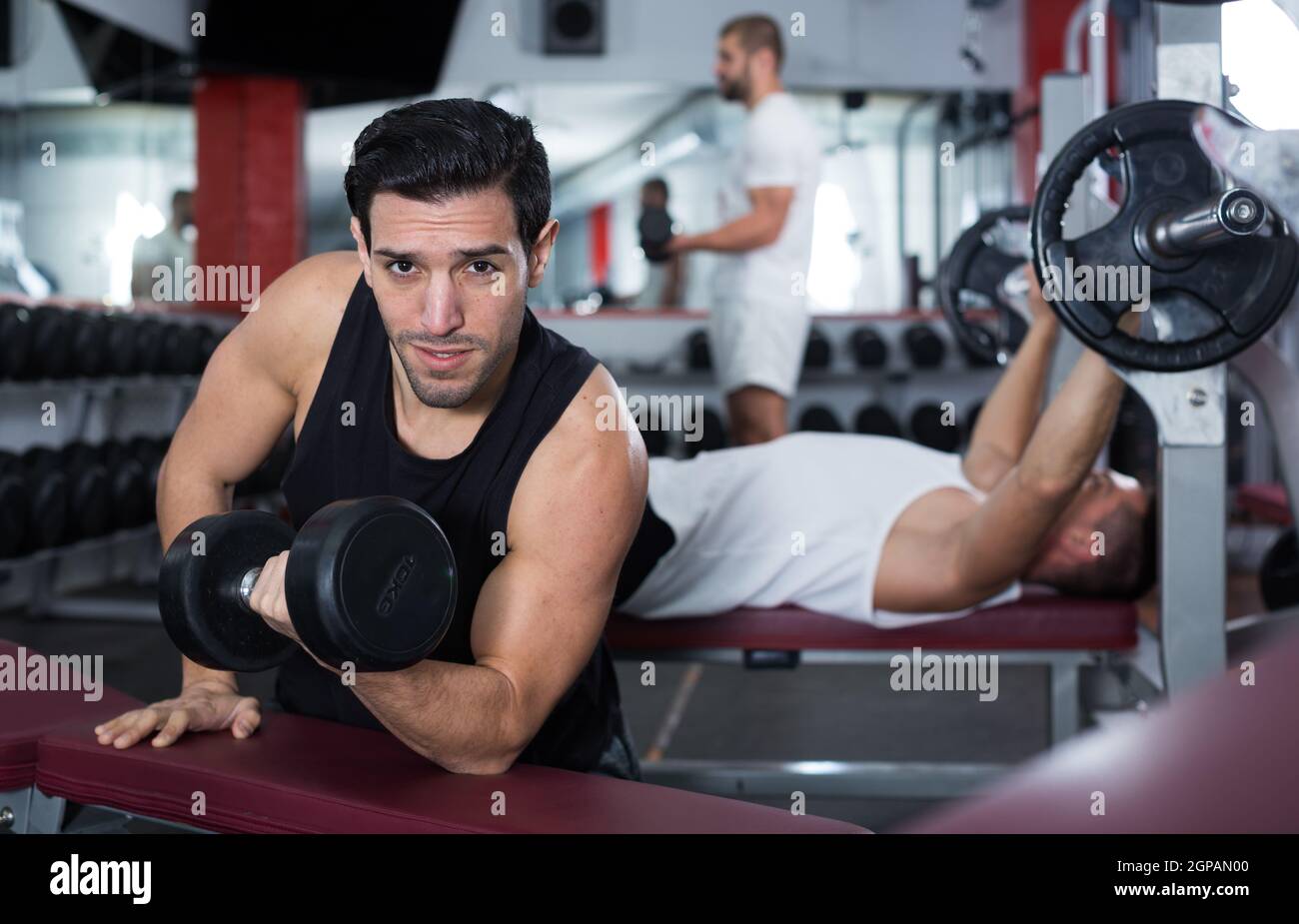 Guy during workout in gym with dumbbells Stock Photo - Alamy
