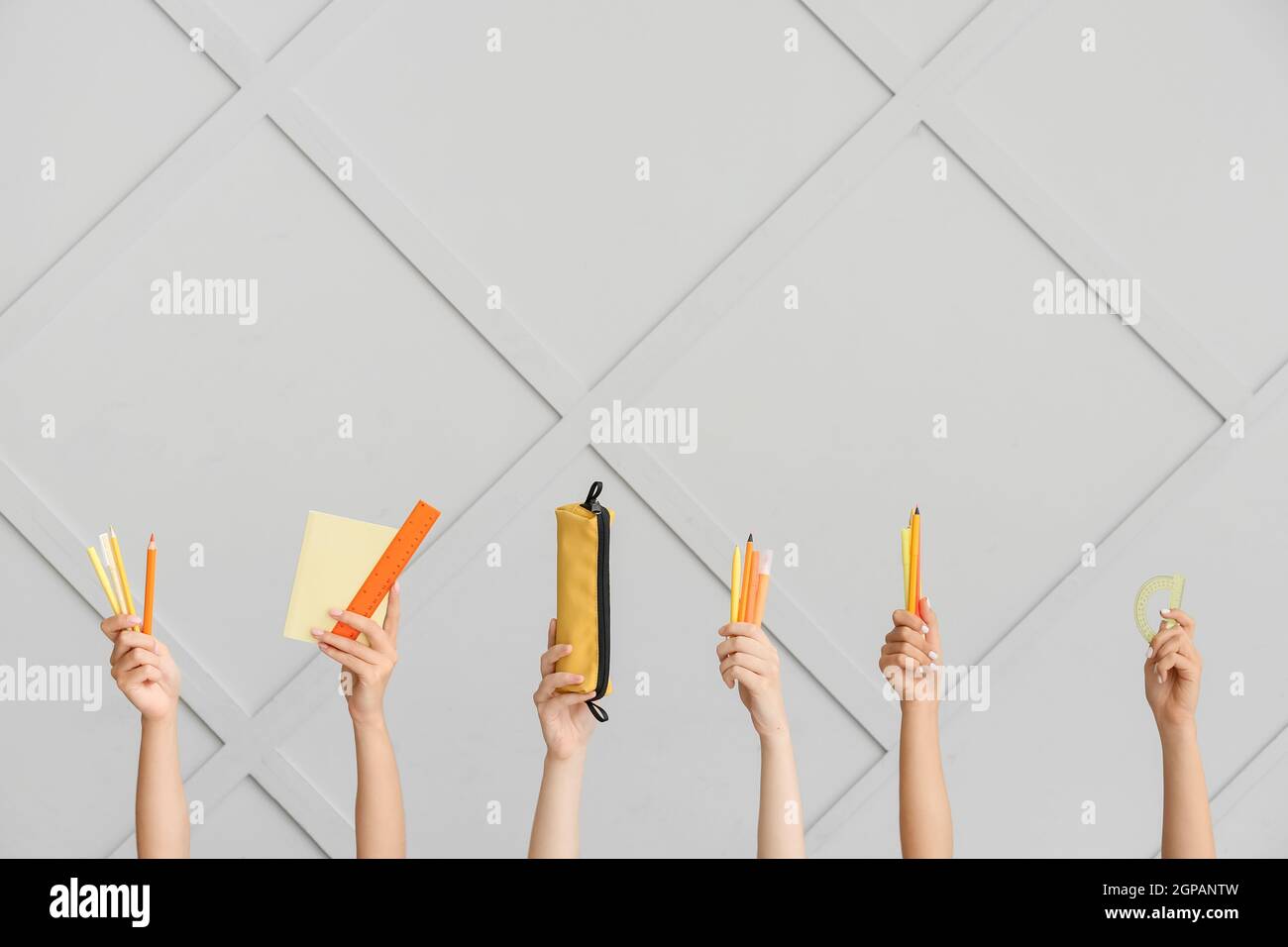 Many different hands with school supplies on grey wall background Stock ...