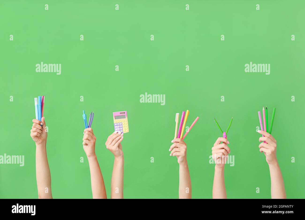 Many different hands with school supplies on green background Stock ...