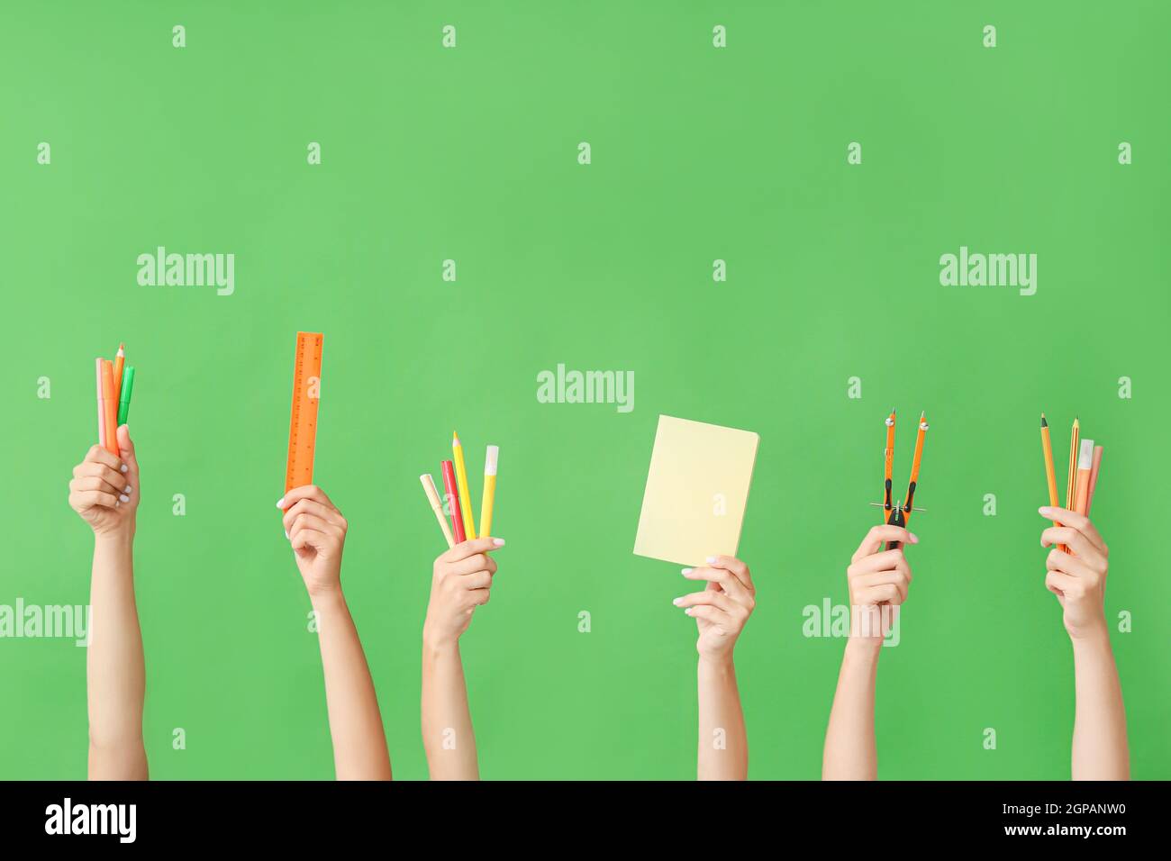 Many different hands with school supplies on green background Stock ...