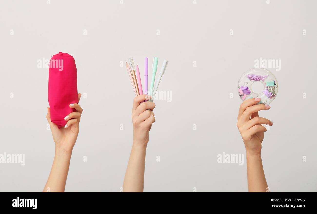 Female hands with school supplies on grey background Stock Photo - Alamy