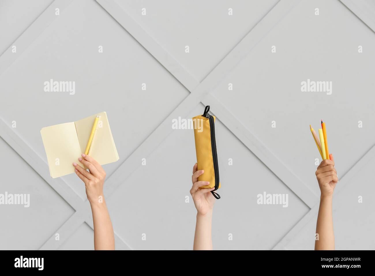 Female hands with school supplies on grey wall background Stock Photo ...