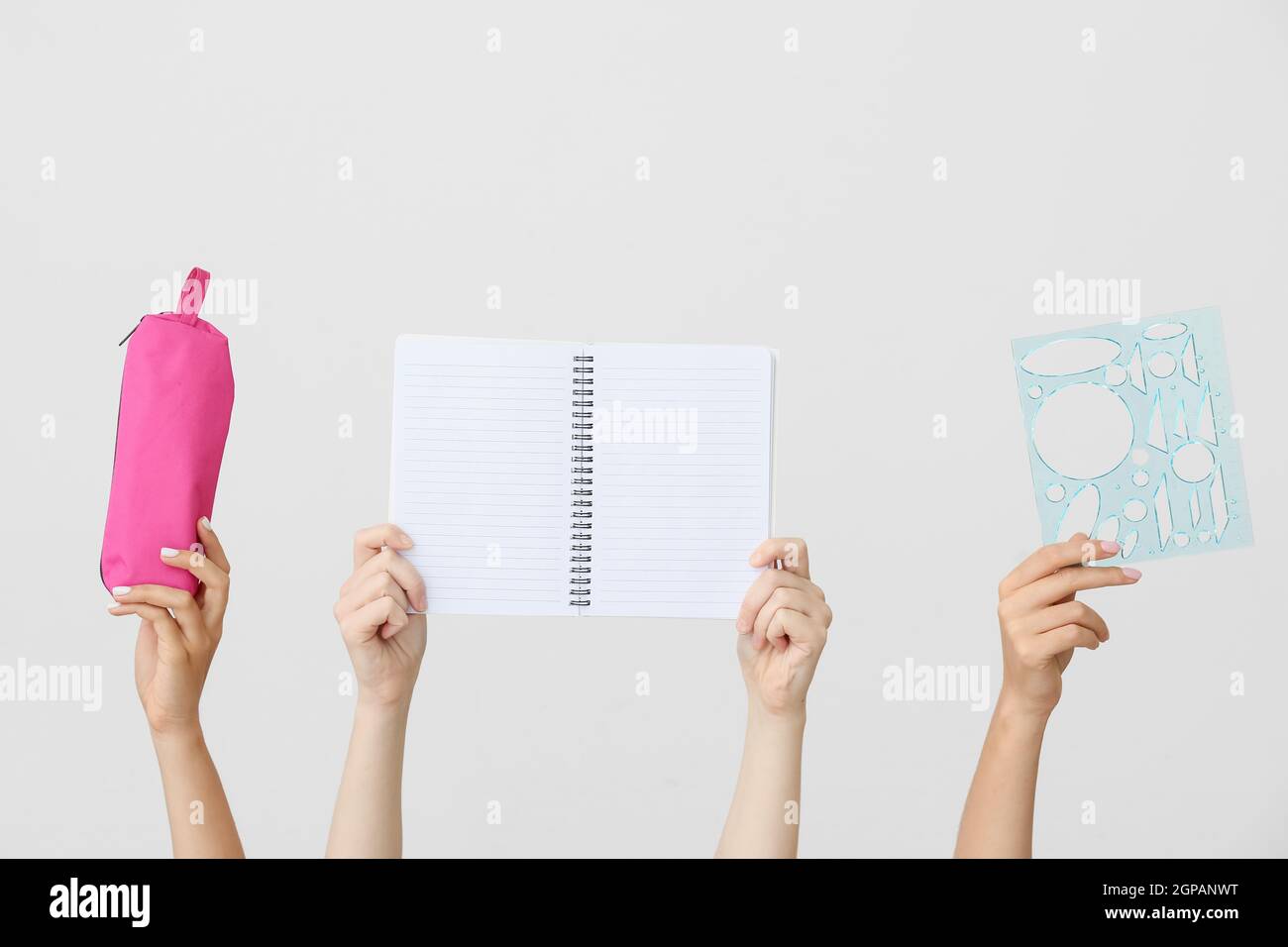 Female hands with school supplies on grey background Stock Photo - Alamy