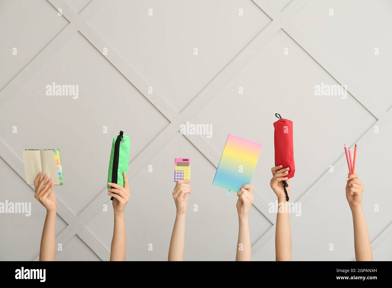 Many different hands with school supplies on grey wall background Stock ...