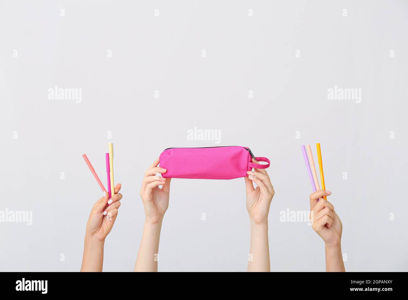 Female hands with school supplies on grey background Stock Photo - Alamy