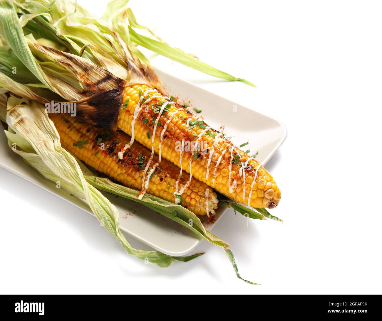 Plate with delicious grilled Mexican street corn on white background ...