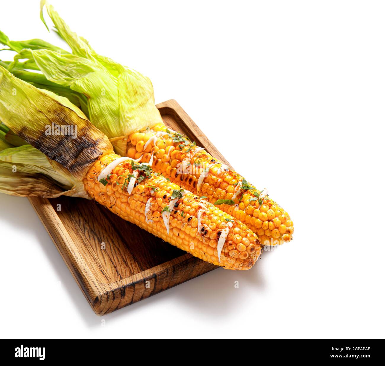 Wooden board with delicious grilled Mexican street corn on white ...