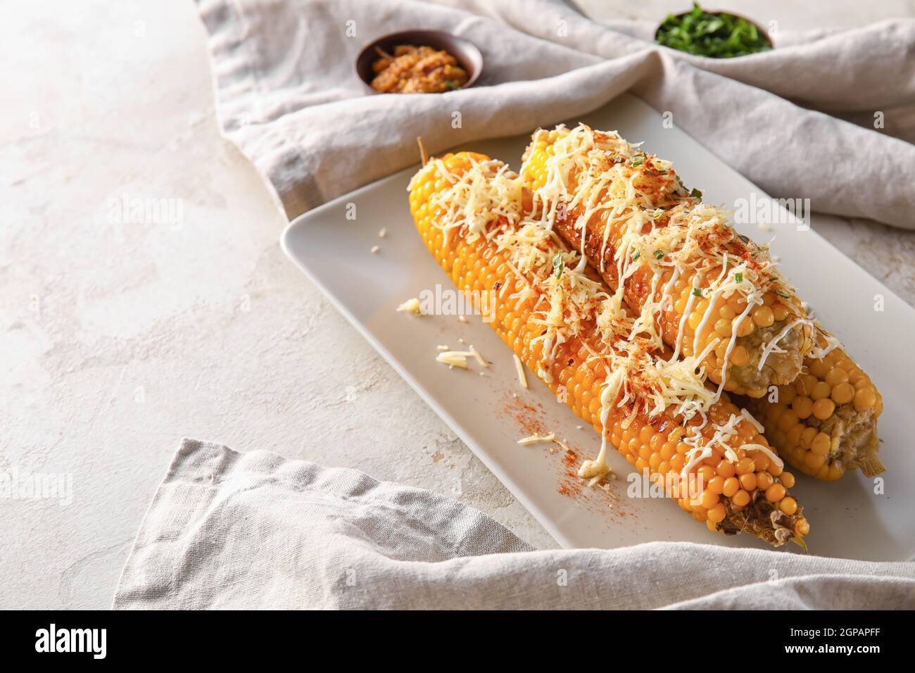 Plate with delicious Elote Mexican Street Corn on light background ...