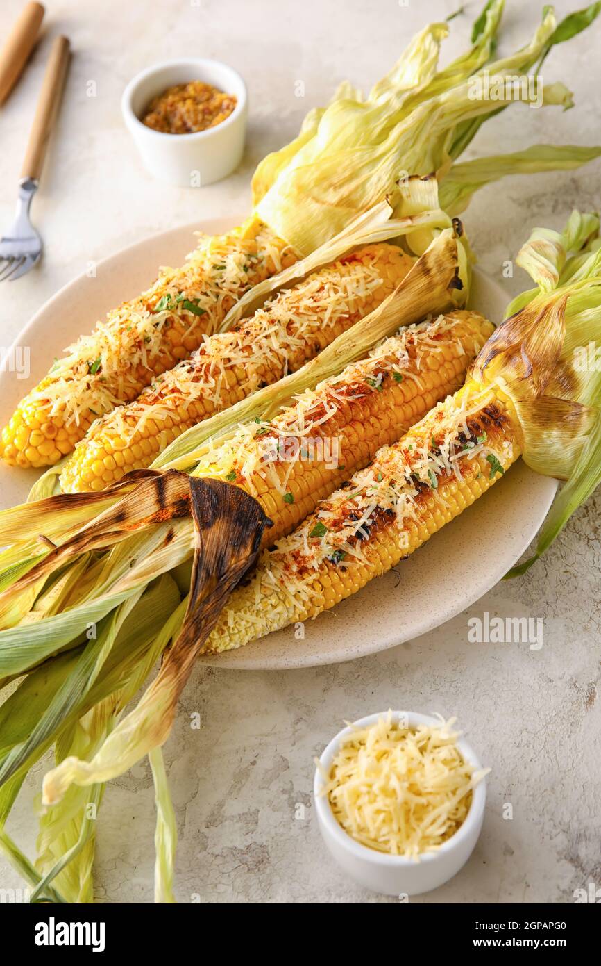 Plate with delicious Elote Mexican Street Corn on light background ...