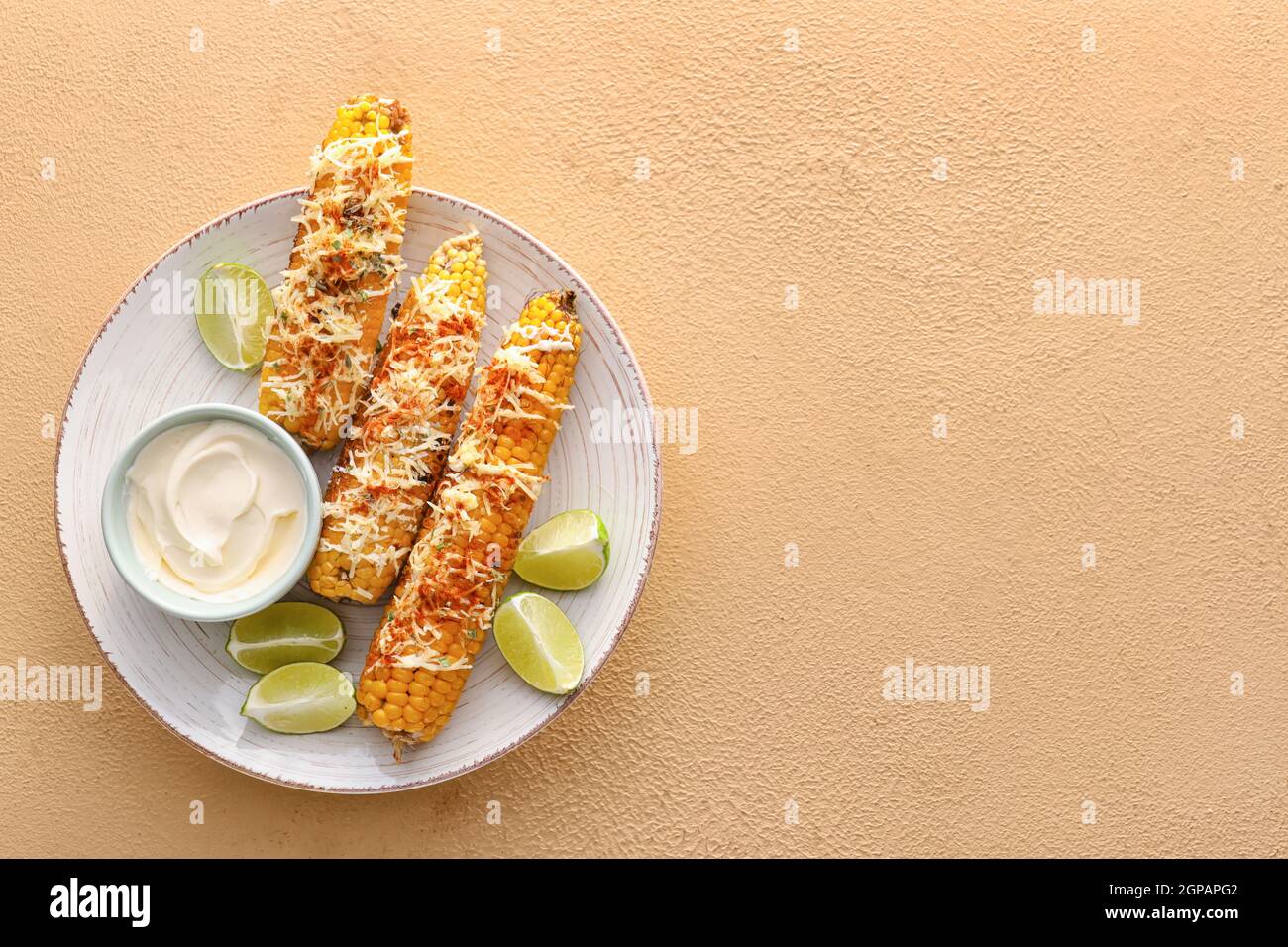 Plate with delicious Elote Mexican Street Corn and mayonnaise on beige ...