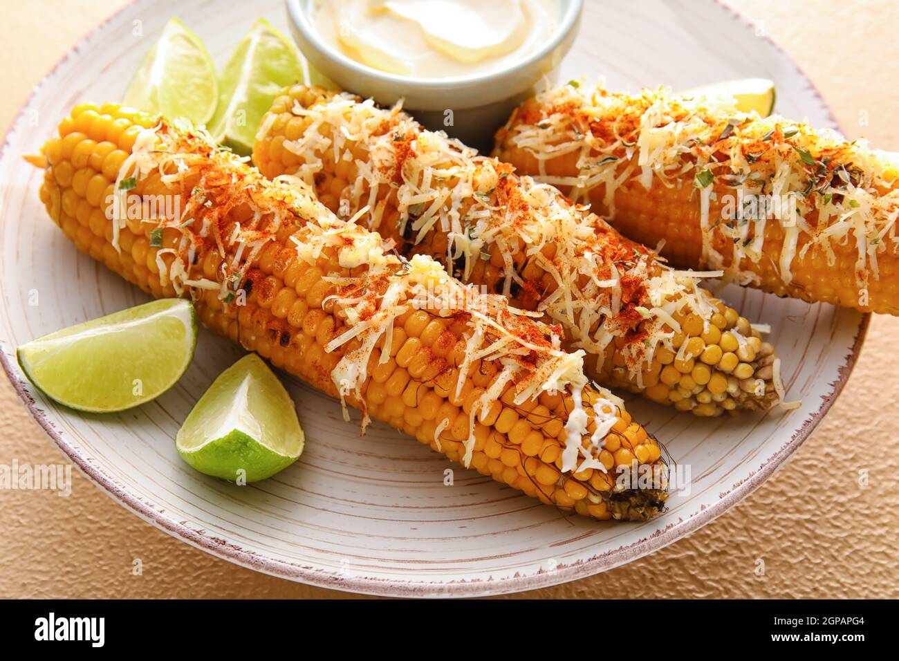 Plate with delicious Elote Mexican Street Corn and mayonnaise on beige ...