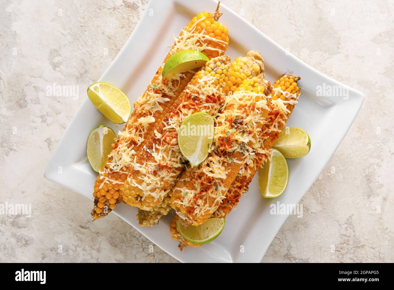 Plate with delicious Elote Mexican Street Corn on light background ...