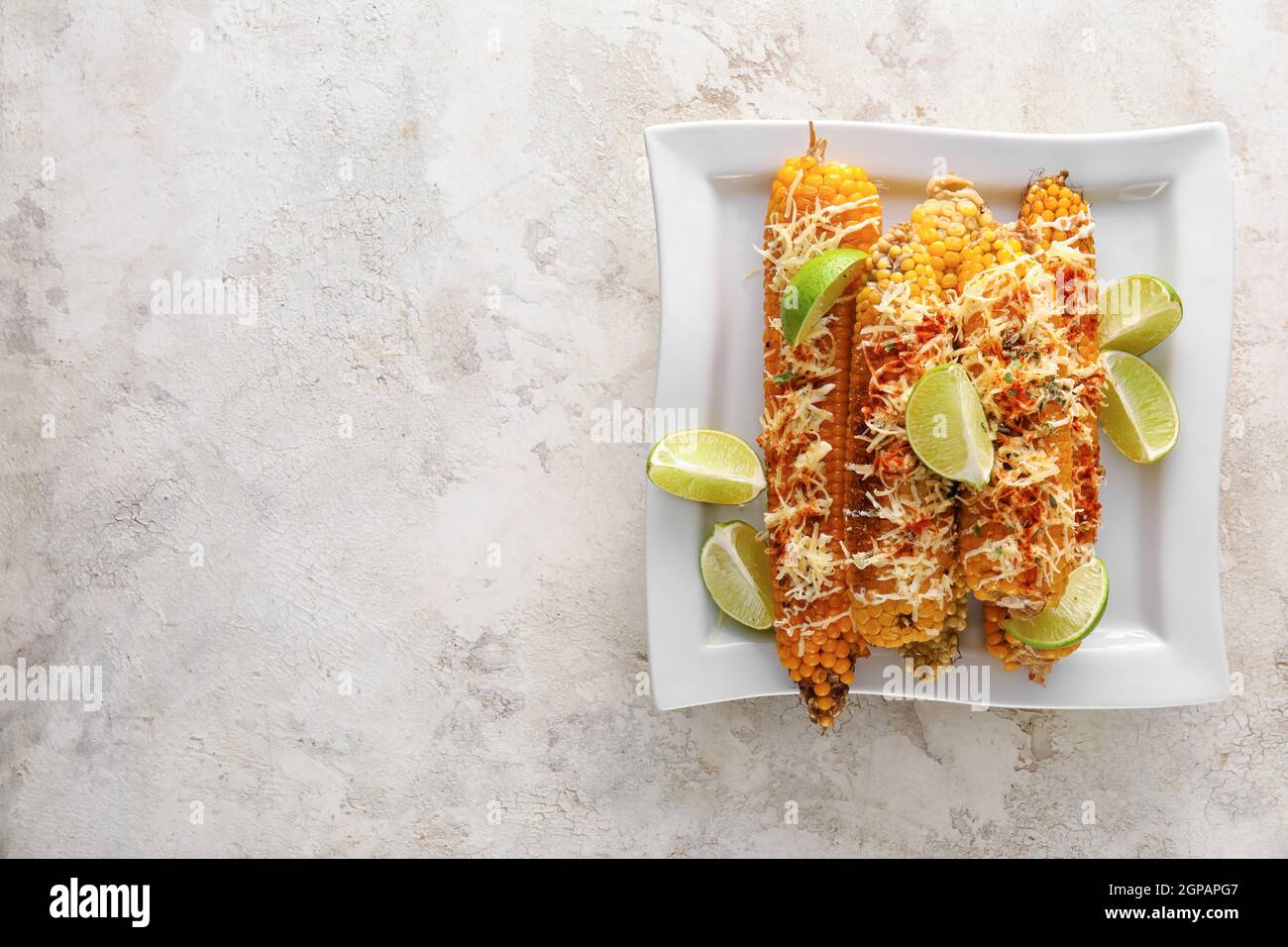 Plate with delicious Elote Mexican Street Corn on light background ...