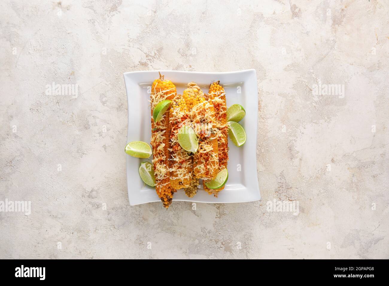 Plate with delicious Elote Mexican Street Corn on light background ...