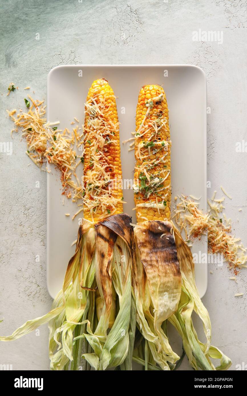 Plate with delicious Elote Mexican Street Corn on light background ...