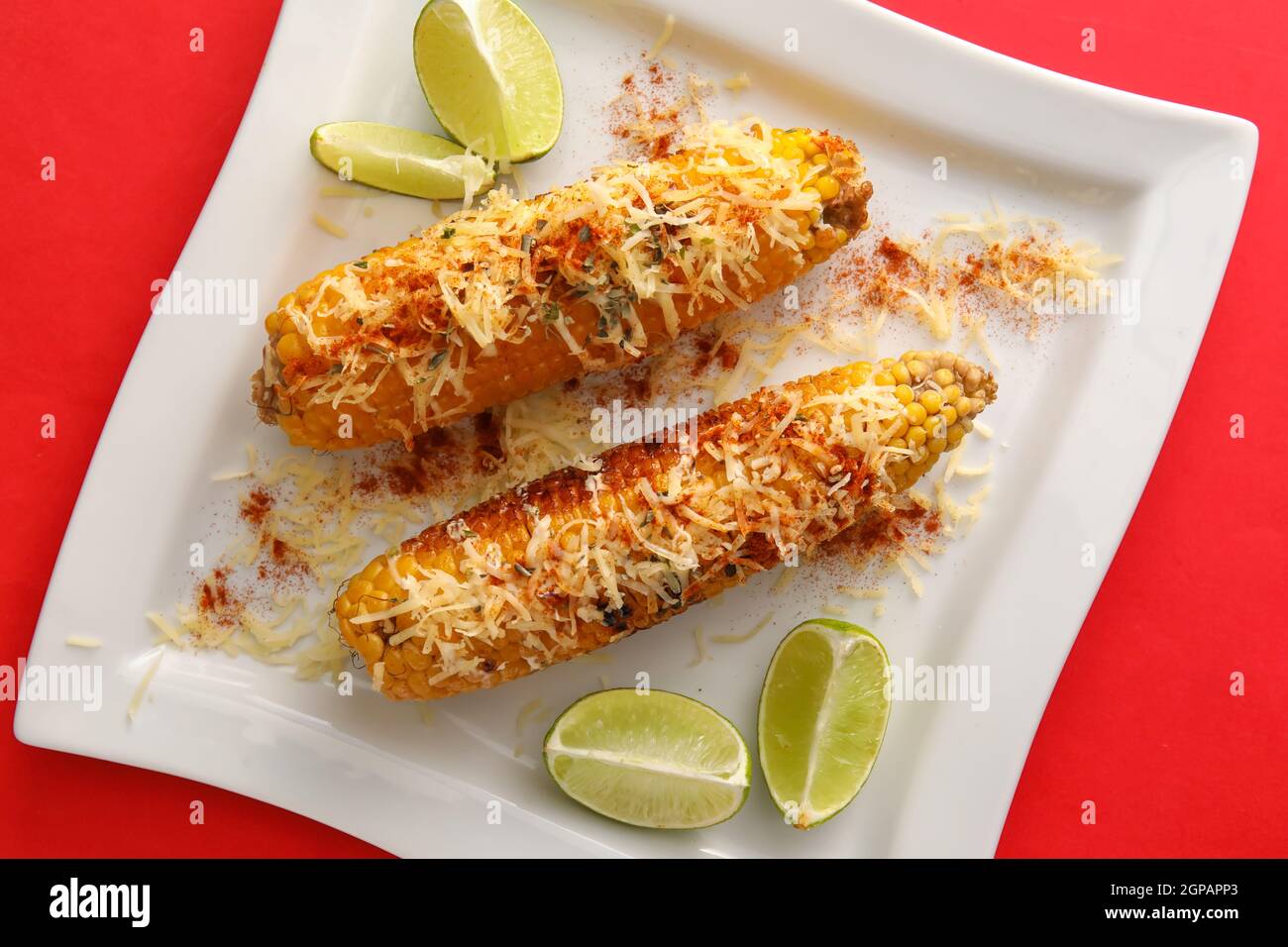 Plate with delicious Elote Mexican Street Corn on red background Stock ...