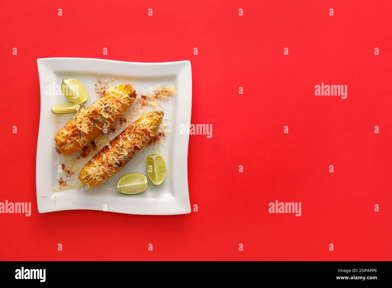 Plate with delicious Elote Mexican Street Corn on red background Stock ...