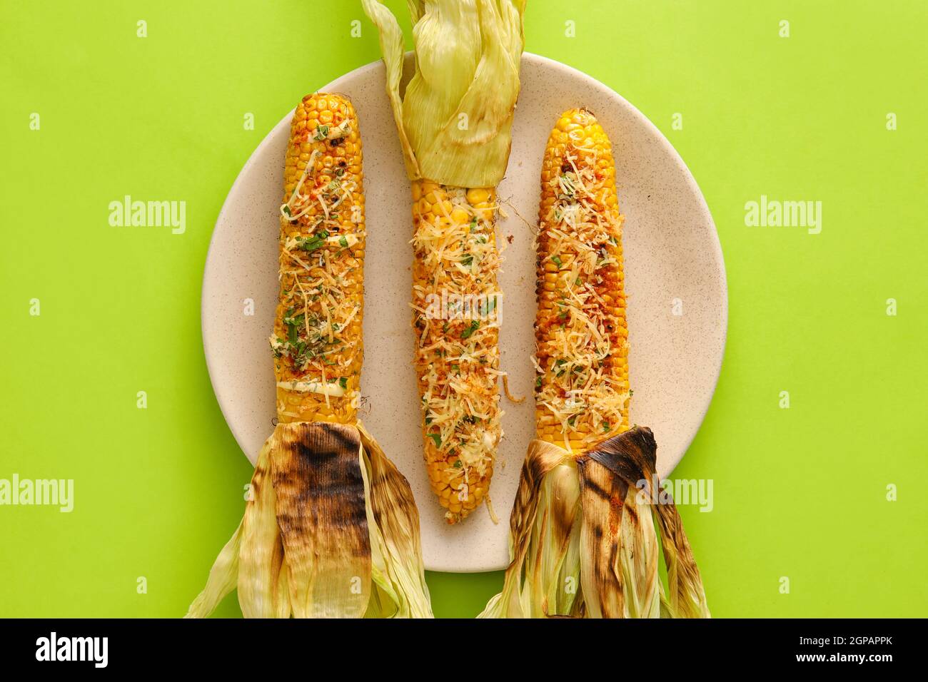 Plate with delicious Elote Mexican Street Corn on green background ...
