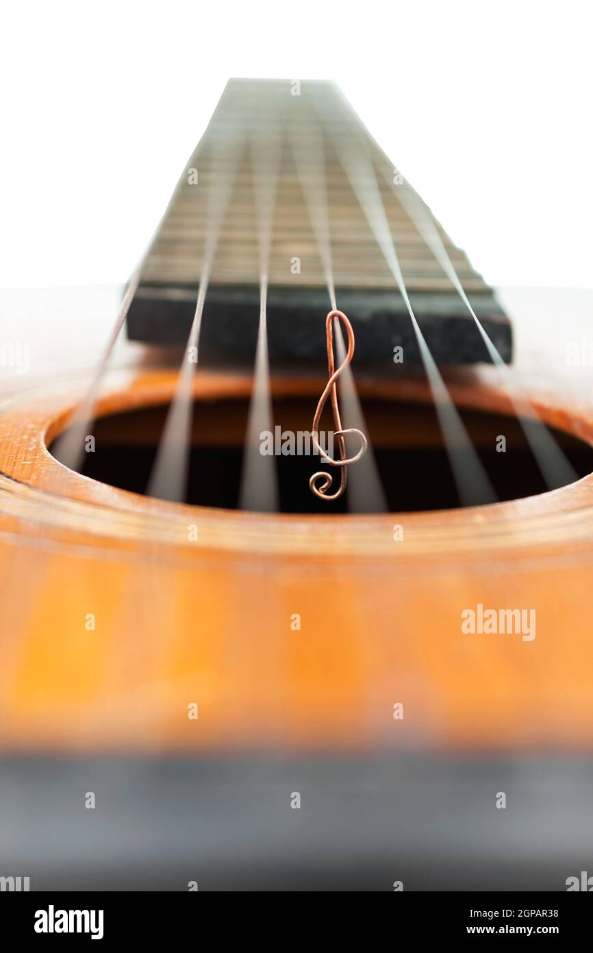 Treble clef on the strings of a guitar, isolated on white Stock Photo ...