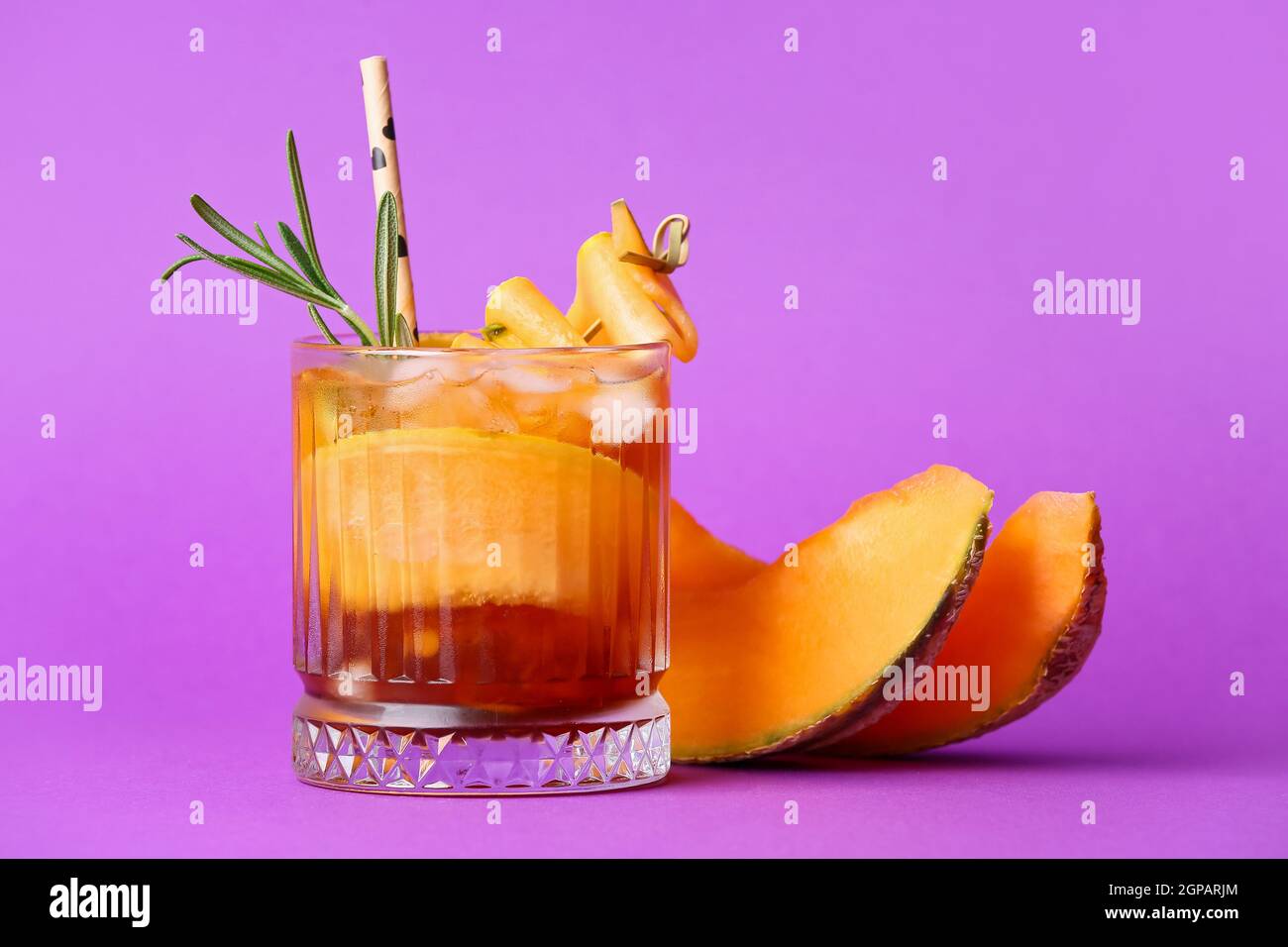 Glass of cold cocktail and melon on lilac background Stock Photo - Alamy