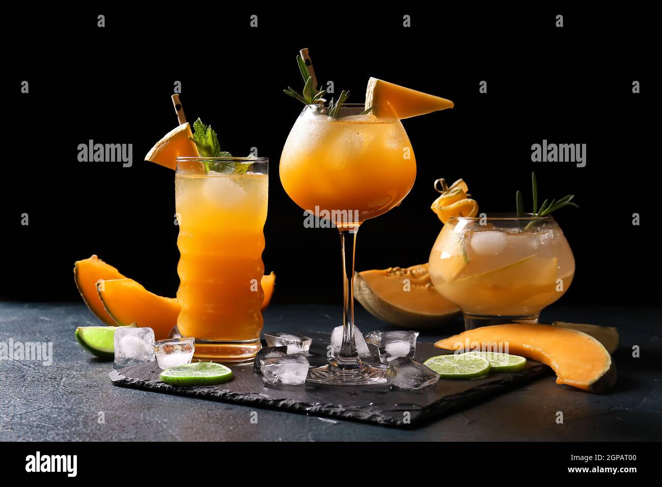 Glasses of cold melon cocktail and ice cubes on dark background Stock ...