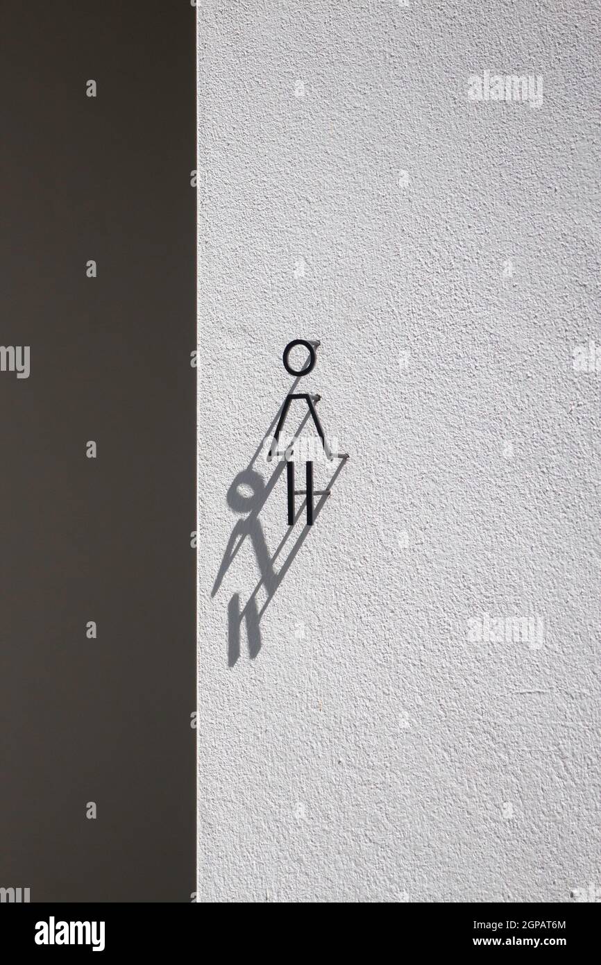 Modern sign shadow of outdoor toilet Stock Photo - Alamy
