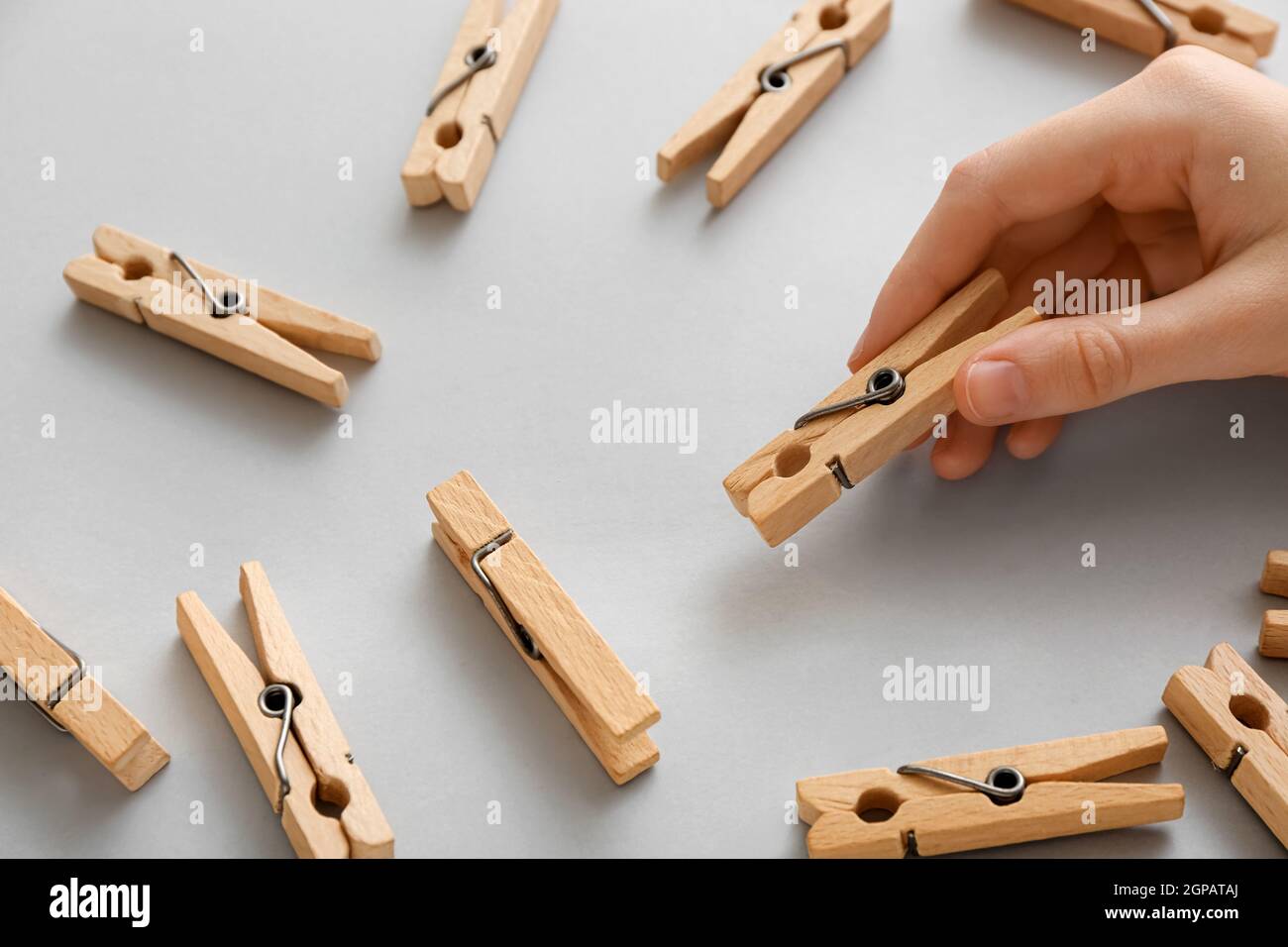 Female hand with clothespins on grey background Stock Photo - Alamy