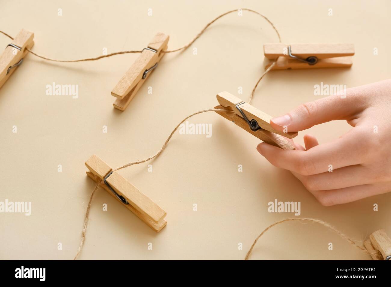 Female hand with clothespins and rope on beige background Stock Photo ...