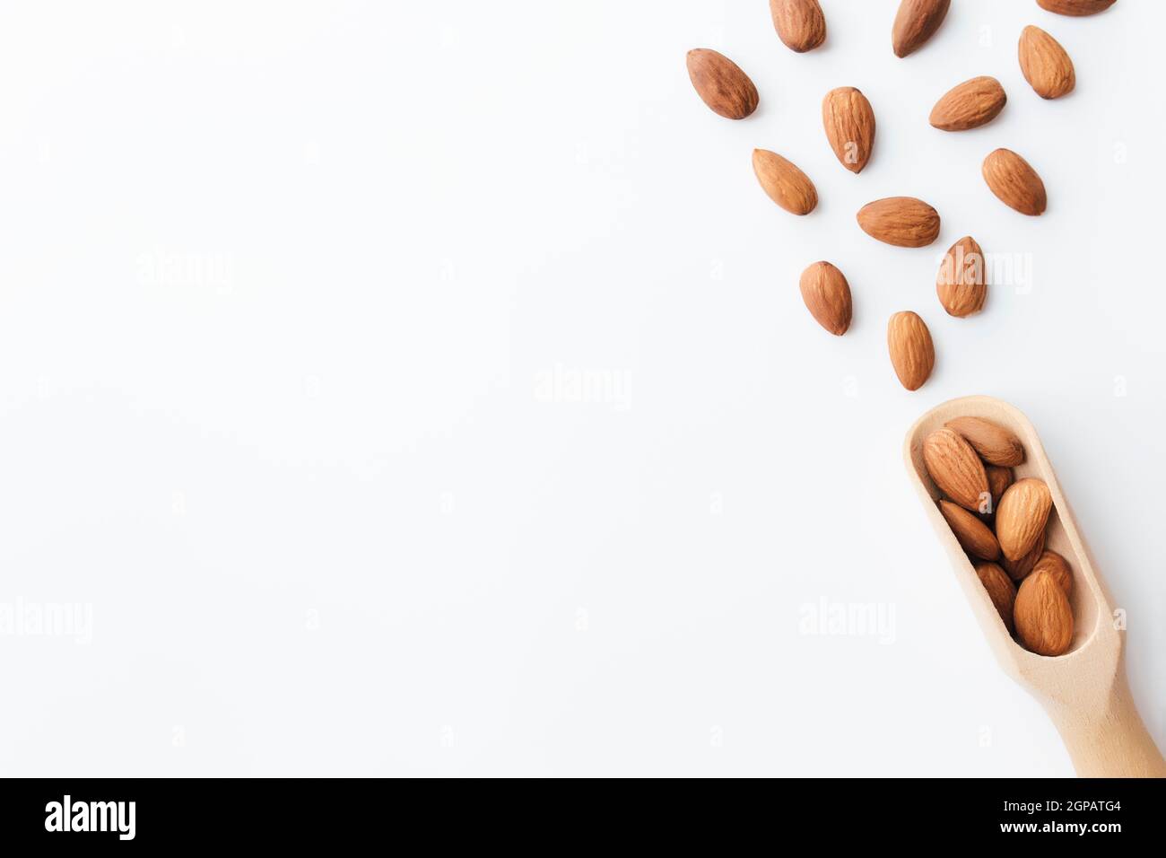 Raw almond kernels in wooden spoon on white background. Cosmetic and ...