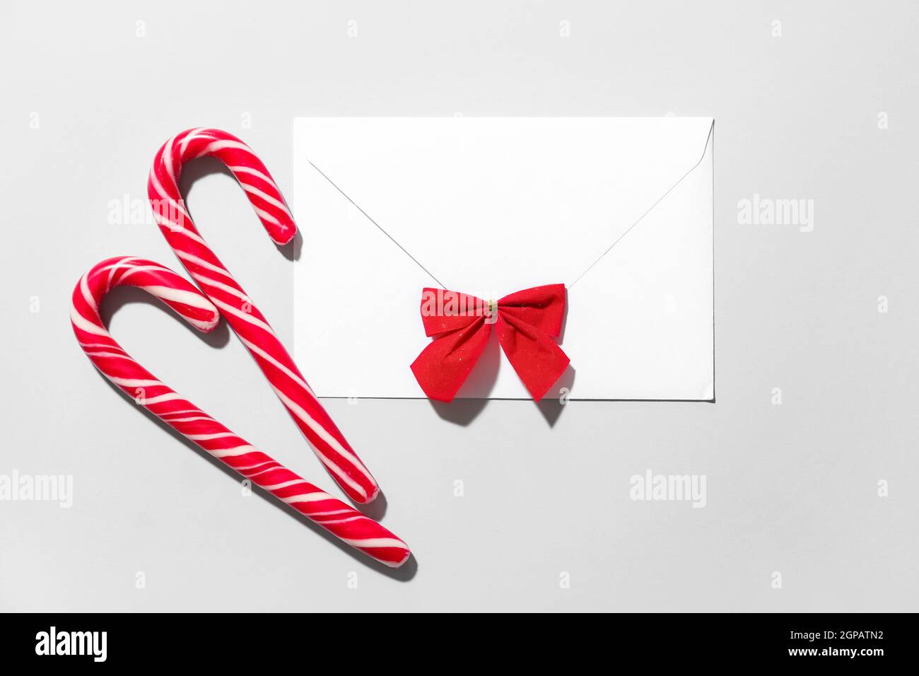 Christmas composition with candy canes and letter on light background ...