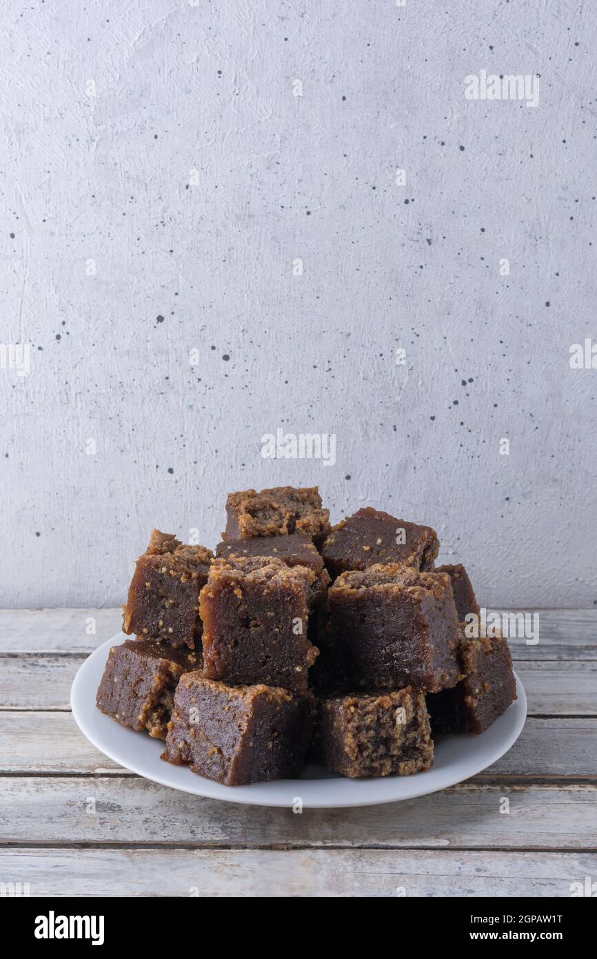 plate of dodol on a wooden table, also called kalu dodol, sri lankan ...