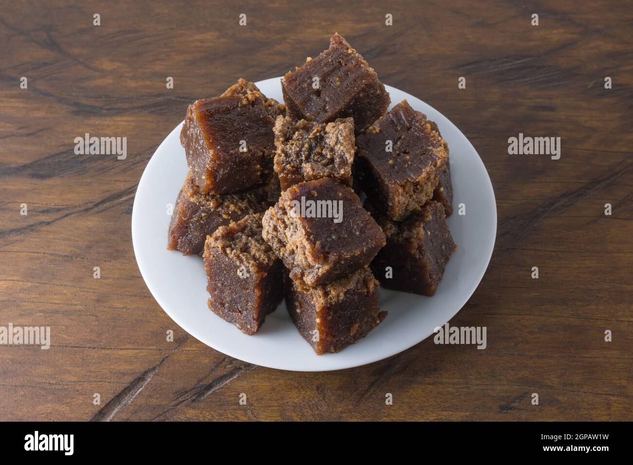 plate of dodol on a wooden table, also called kalu dodol, sri lankan ...
