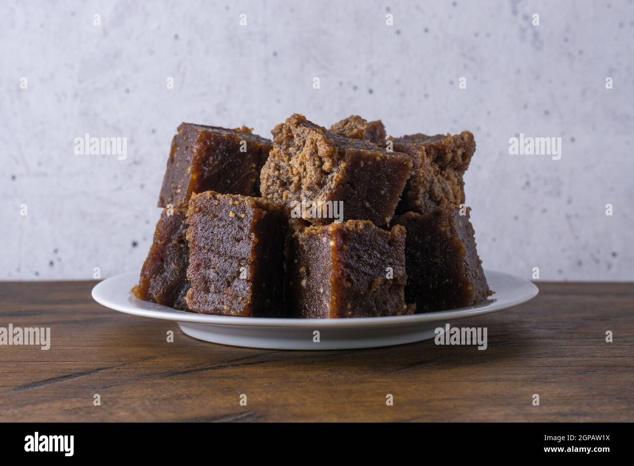 plate of dodol on a wooden table, also called kalu dodol, sri lankan ...