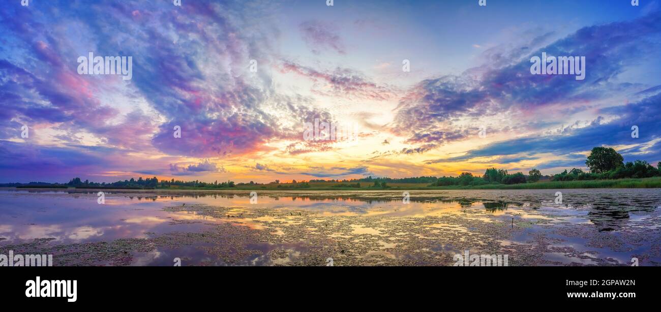 Panorama with beautiful colorful sunrise over lake Stock Photo - Alamy