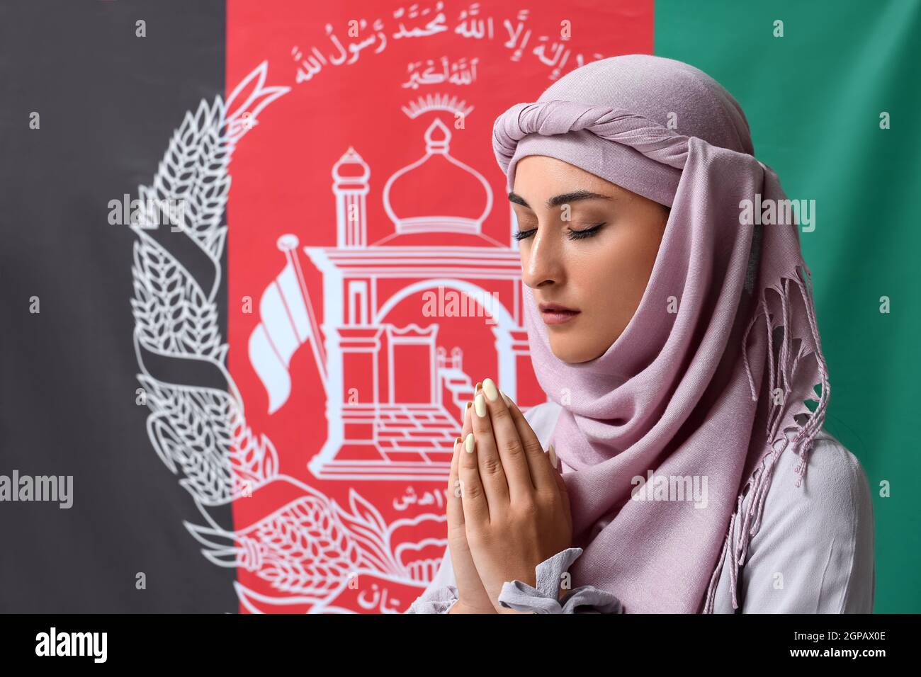Praying Muslim woman against flag of Afghanistan Stock Photo - Alamy