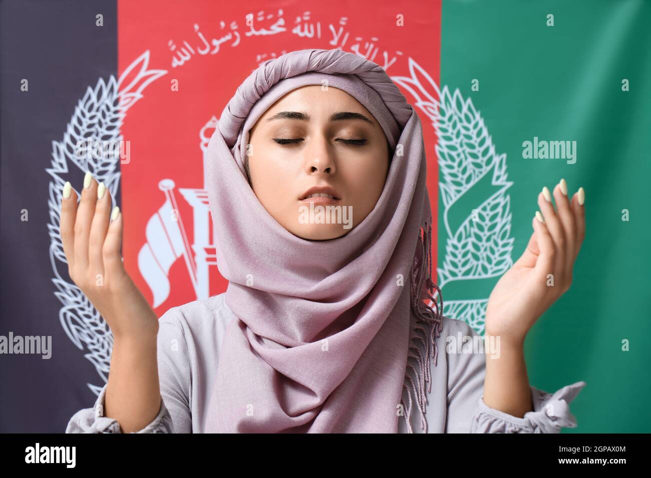 Praying Muslim woman against flag of Afghanistan Stock Photo - Alamy